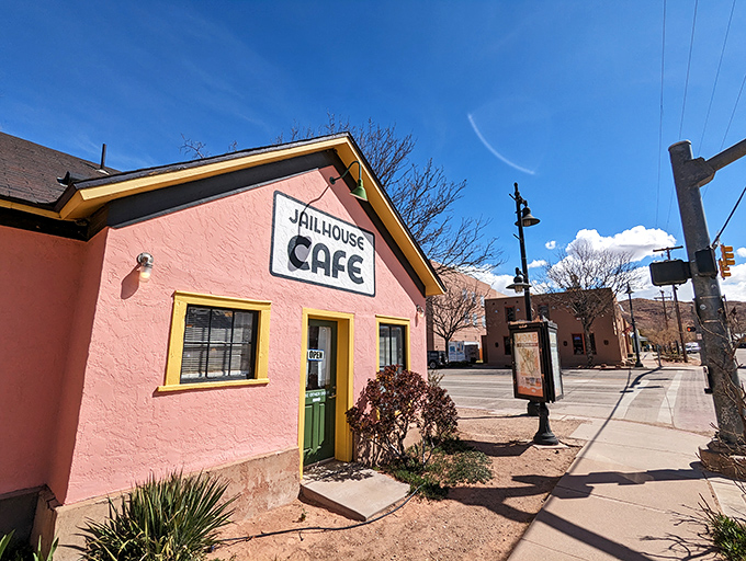 The salmon-pink jailhouse turned breakfast haven stands like a cheerful rebellion against ordinary dining, its yellow door beckoning hungry travelers into delicious captivity.