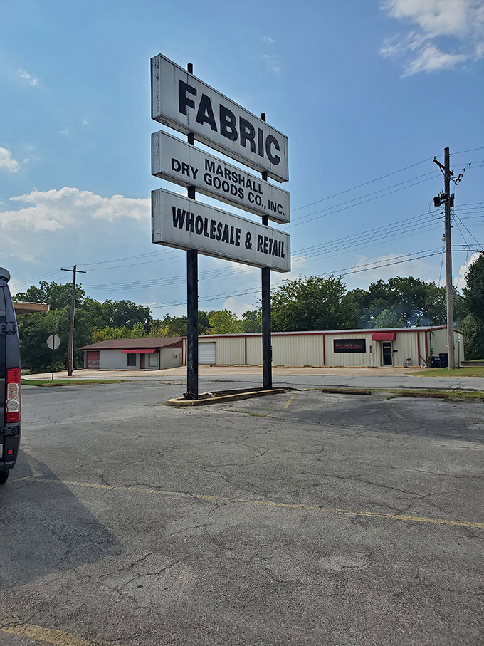 The sign says "FABRIC" with the subtlety of a Broadway marquee. No false advertising here&mdash;just a promise of textile treasures awaiting inside.