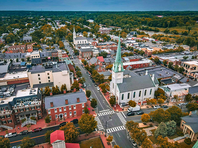 Fredericksburg unfolds like a living history book from above, where church spires punctuate the autumn canopy and brick buildings tell stories centuries old.