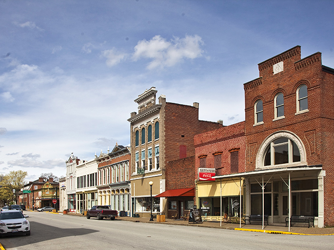 Historic brick facades line New Harmony's main street, where 19th-century architecture meets small-town charm in a perfectly preserved tableau.