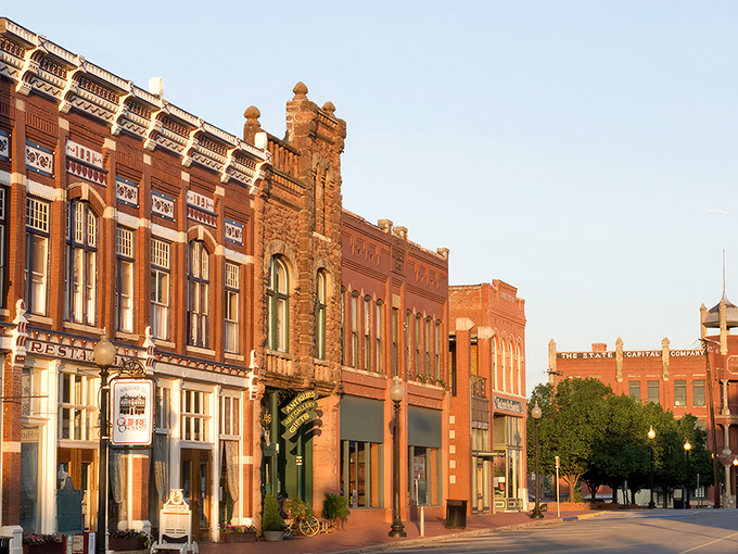 Guthrie's Victorian storefronts stand proudly like architectural time travelers. That mint-green Daylight Donuts sign promises sweet rewards for early risers. 