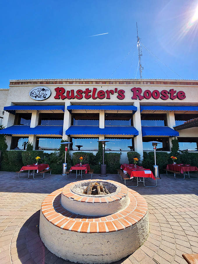 The welcoming facade of Rustler's Rooste stands proud against the Arizona sky, where blue awnings and red tablecloths hint at the Western hospitality waiting inside.
