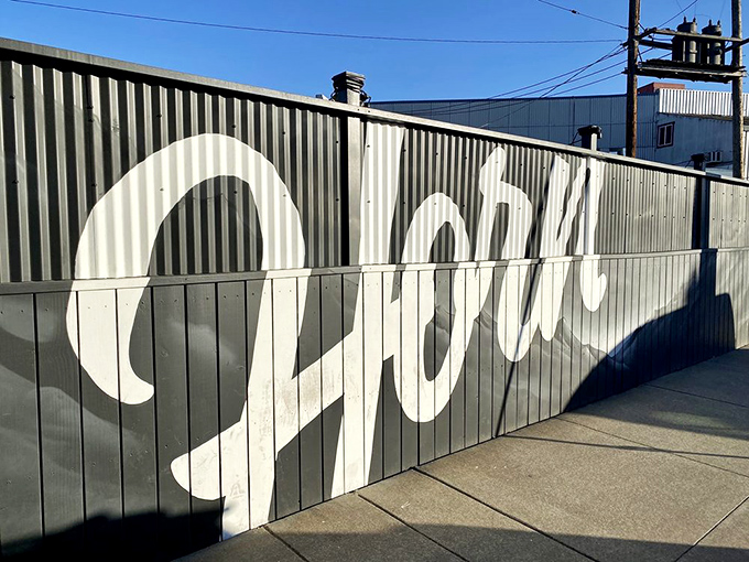 The unassuming exterior of Horn BBQ in Oakland &ndash; where that bold white lettering against dark panels is the architectural equivalent of a whisper about the best-kept secret in town.