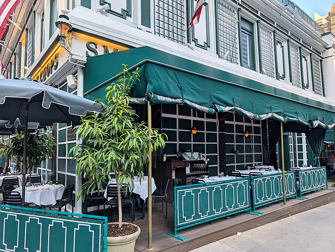 The iconic white building with green awnings stands like a time capsule amid Manhattan's glass towers, American flags proudly waving above this temple of beef.