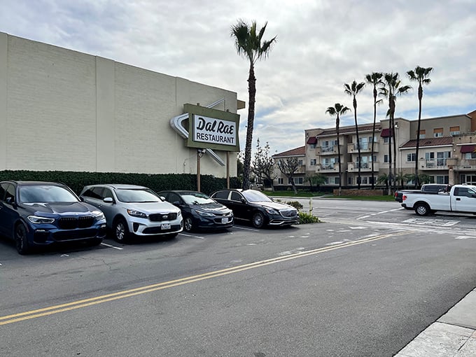 The neon sign beckons like a lighthouse for hungry souls. Palm trees and classic cars complete this quintessential Southern California supper club scene.