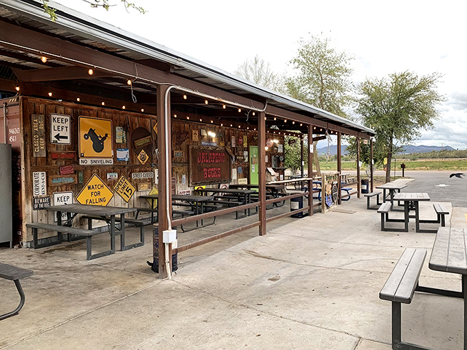 The rustic roadside charm of Jalape&ntilde;o Buck's beckons hungry travelers with its weathered metal roof and promise of smoky delights ahead.