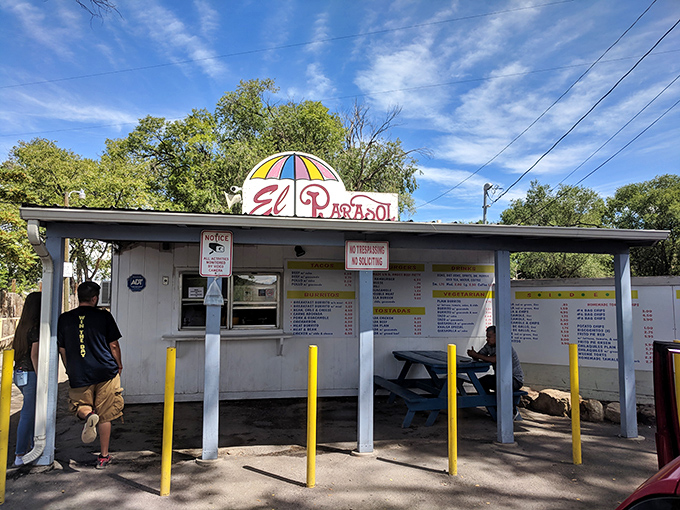 The humble roadside stand with its cheerful umbrella logo promises more flavor per square foot than establishments ten times its size.