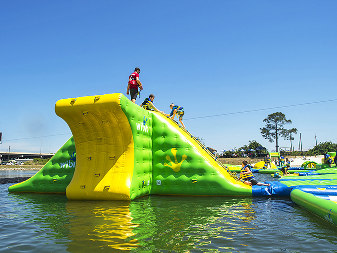 The neon green floating playground beckons like an aquatic Wonderland. Who needs expensive theme parks when paradise is floating right here?