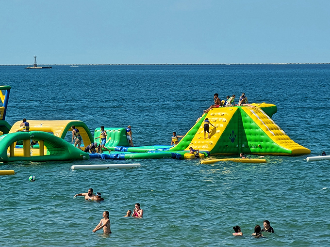 The ultimate adult recess has arrived! Vibrant yellow and green inflatables bob on Lake Michigan's blue waters, promising aquatic adventures that'll make your inner child squeal with delight.