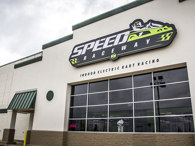 The vibrant green exterior beckons speed enthusiasts like a neon sign in the desert. Racing paradise awaits behind those unassuming walls.