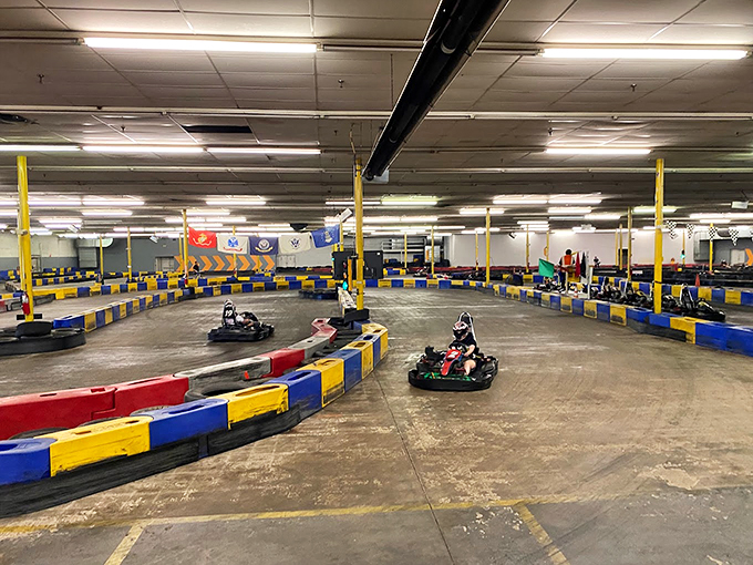 The sprawling indoor track beckons speed enthusiasts with its winding course and colorful barriers. Racing nirvana awaits under these fluorescent lights.