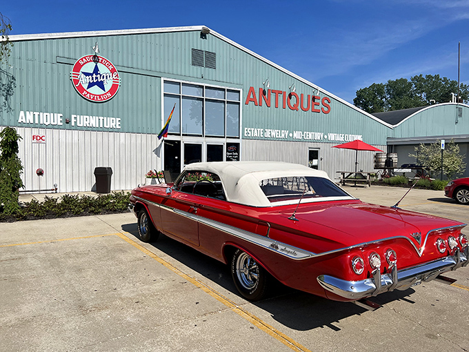 The mint-green exterior of Saugatuck Antique Pavilion stands proudly against a blue Michigan sky, with a classic convertible parked out front&mdash;nostalgia in architectural and automotive form.