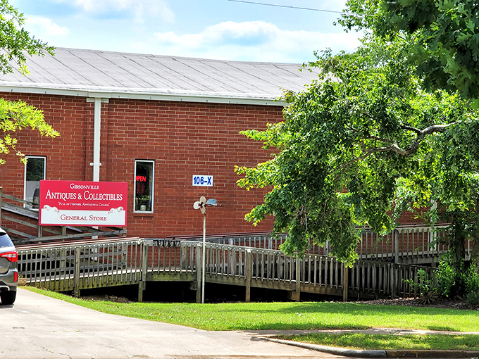 The unassuming brick fa&ccedil;ade with its vintage metal chairs and flamingo sentinel&mdash;proof that the best treasure maps often start with a simple "ANTIQUES" sign.