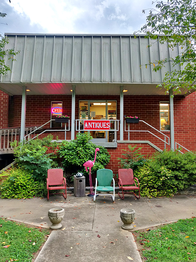 The unassuming brick fa&ccedil;ade with its vintage metal chairs and flamingo sentinel&mdash;proof that the best treasure maps often start with a simple "ANTIQUES" sign.