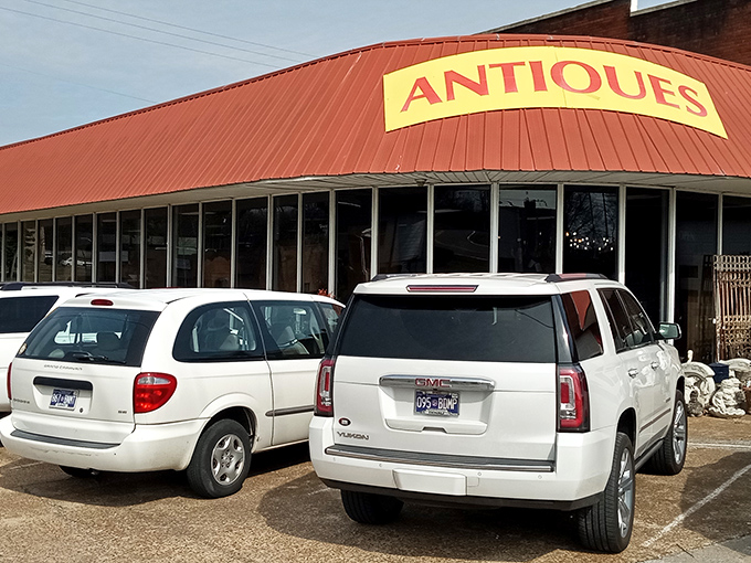 Peek down a corridor of curiosities where treasure hunters navigate a sea of vintage wonders under the watchful eye of a blue bicycle suspended in mid-flight.