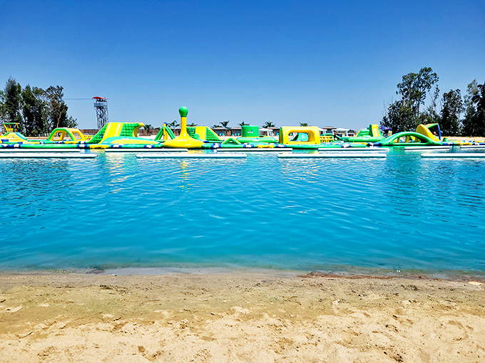 The aquatic playground stretches across crystal-clear water like a neon-colored mirage, promising adventures that'll make your inner child high-five your outer adult.