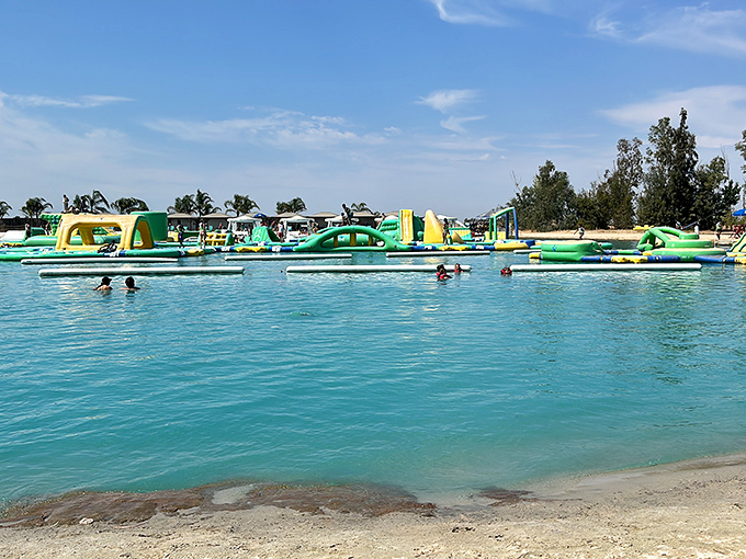The aquatic playground stretches across crystal-clear water like a neon-colored mirage, promising adventures that'll make your inner child high-five your outer adult.