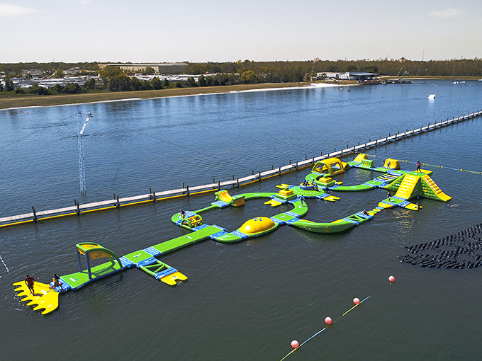 The neon green floating playground beckons like an aquatic Wonderland. Who needs expensive theme parks when paradise is floating right here?