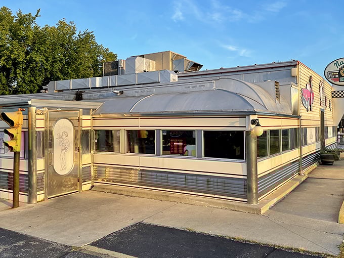 The gleaming silver exterior of Nancy's Main Street Diner stands like a time capsule on wheels, complete with vintage signage and classic car artwork.