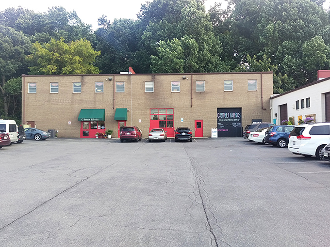 The unassuming exterior hides a crafter's paradise within, like finding Willy Wonka's factory but for fabric enthusiasts. Those colorful quilt murals are just the appetizer.