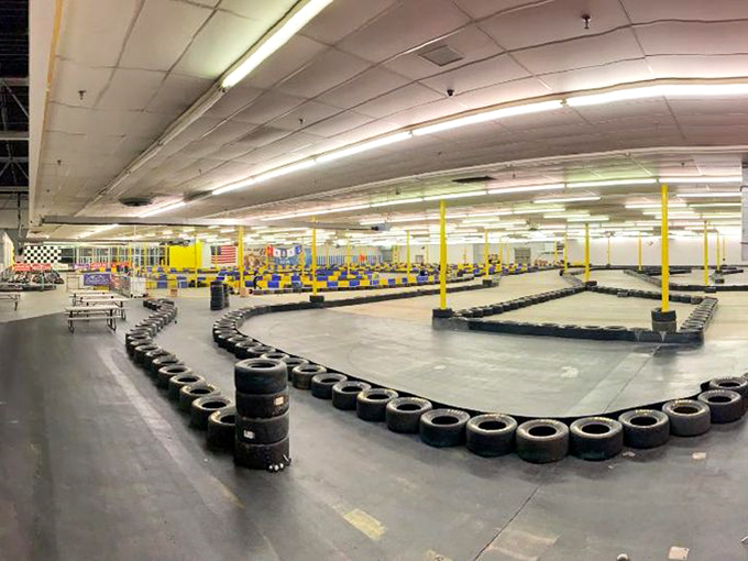 The sprawling indoor track beckons speed enthusiasts with its winding course and colorful barriers. Racing nirvana awaits under these fluorescent lights.