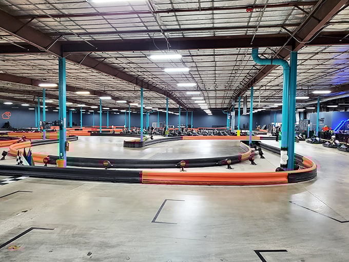 The thrill of the chase! Electric karts zip around tight corners as drivers lean into turns, their focused expressions visible even through helmets.