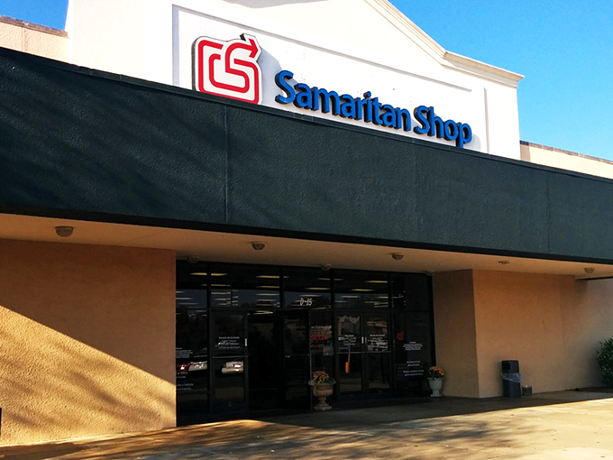 The exterior of Samaritan Shop stretches wide like a treasure chest waiting to be opened, its blue banner promising adventures in second-hand splendor.