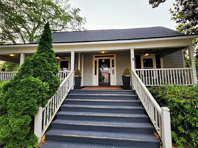 The stately front porch welcomes you like a Southern grandmother—elegant, inviting, and hiding delicious secrets behind that charming façade.