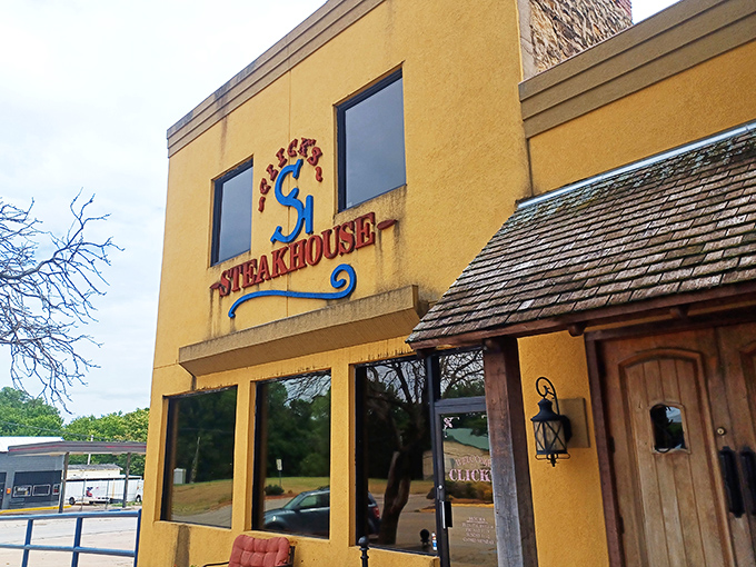 The bright yellow exterior of Click's Steakhouse stands like a beacon of carnivorous delight in Pawnee, promising beef-based bliss to those wise enough to make the journey.