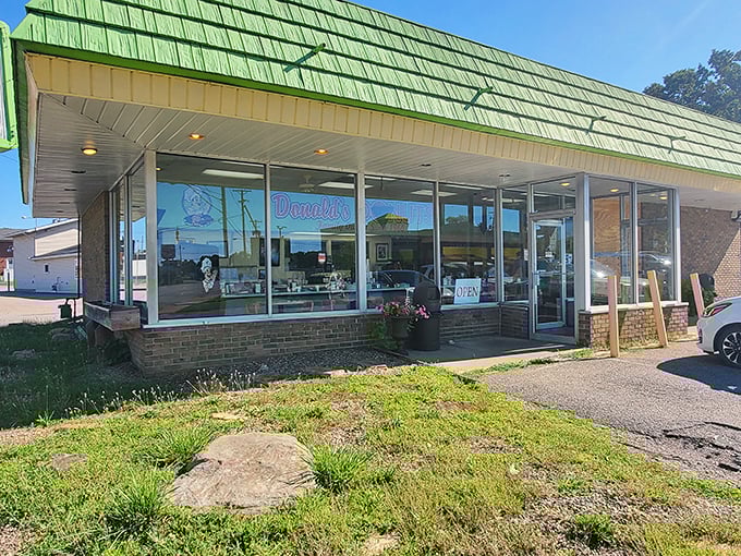 The mint-green shingled roof beckons like a sugar-coated lighthouse, guiding hungry travelers to this unassuming temple of fried dough excellence.