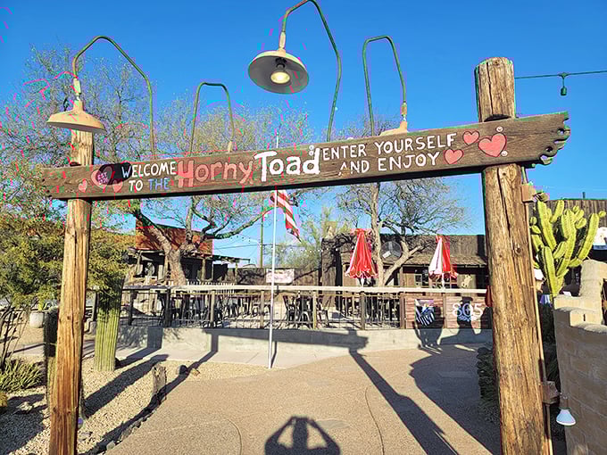 The Horny Toad's weathered wooden exterior stands like a time capsule of the Wild West, complete with saguaro sentinels guarding desert-worn pathways. 