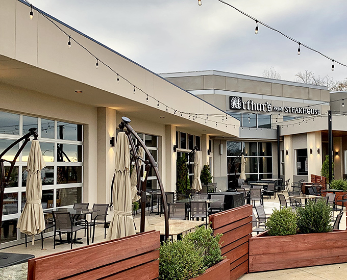 The modern fa&ccedil;ade of Arthur's Prime Steakhouse belies the old-world charm within. String lights create an inviting glow as evening approaches.