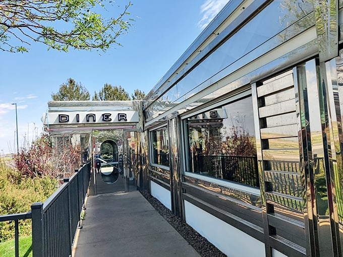 The classic silver exterior of Moonlight Diner gleams in the Colorado sunshine, a chrome time capsule promising comfort food and nostalgia just steps from Denver International Airport.