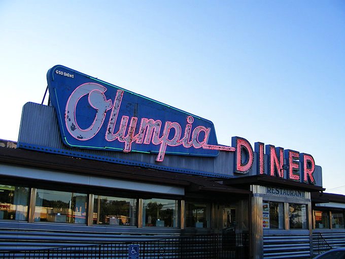 That neon sign isn't just advertising&mdash;it's a time machine. The Olympia's iconic blue and pink glow has been guiding hungry travelers home since Eisenhower was president.