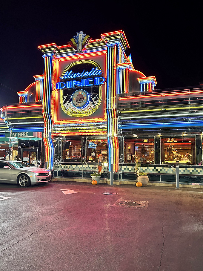 The neon-drenched facade of Marietta Diner glows like a beacon for hungry souls, a chrome-clad time machine promising comfort food and nostalgia.