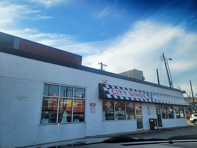 The classic white brick exterior with black and white striped awning stands like a time capsule on this Kansas City corner, beckoning hungry patrons with its humble charm.