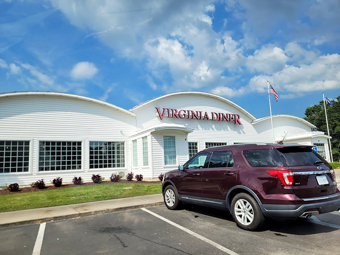 The white curved-roof building with bold red "VIRGINIA DINER" lettering stands proudly against the sky, like a beacon of comfort food calling road-weary travelers home.