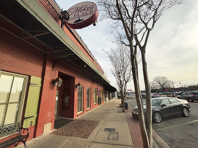 The vibrant red exterior of Mike's Place, framed by blooming crepe myrtles, stands as Conway's culinary beacon for seafood lovers.
