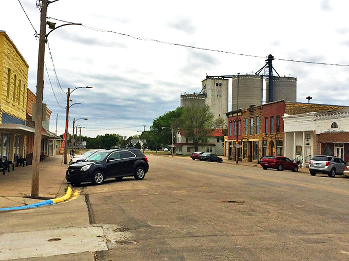 Main Street Lucas stretches toward the horizon, where grain elevators stand like prairie sentinels against the Kansas sky. Small-town America at its most authentic.