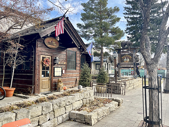 The log cabin exterior of The Kneadery welcomes hungry travelers with rustic charm and hanging flower baskets that say "Yes, breakfast is worth the drive."