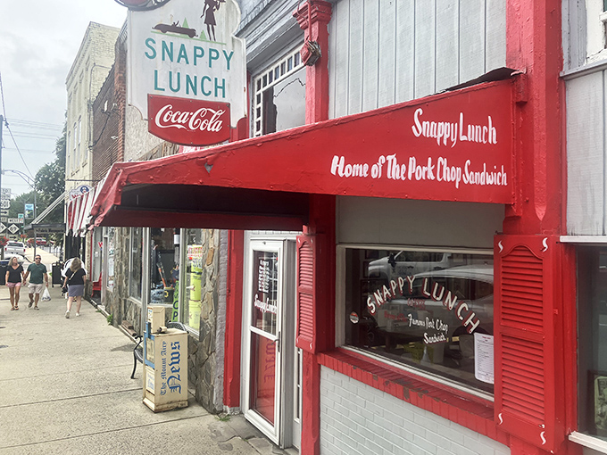 The time-traveling storefront of Snappy Lunch beckons with its cheerful red and blue facade, a nostalgic beacon on Mt. Airy's Main Street since 1923.
