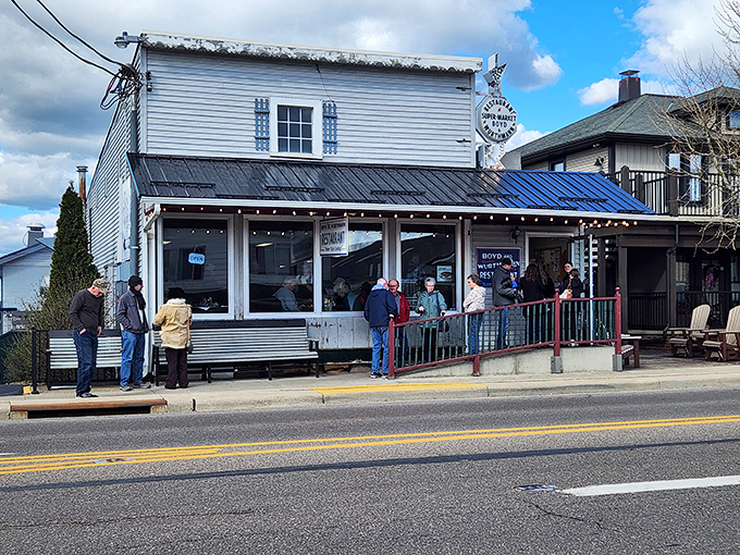 The unassuming white clapboard exterior of Boyd & Wurthmann stands like a time capsule on Berlin's main street, complete with that inviting green bench where friendships begin.