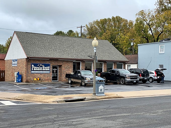 The unassuming brick exterior of L'Dees Pancake House, where pickup trucks in the parking lot signal you've found a true local treasure.