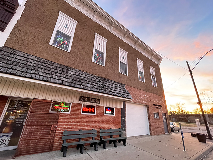 The unassuming brick exterior of Guy & Mae's Tavern stands like a barbecue beacon in tiny Williamsburg, Kansas. Sunset casts a golden glow on this temple of smoked meat perfection.