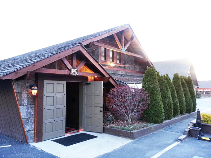 The iconic Peddler sign welcomes hungry travelers with its warm glow and glass-enclosed fire feature&mdash;a beacon of promised culinary delights in Boone's mountain landscape. 