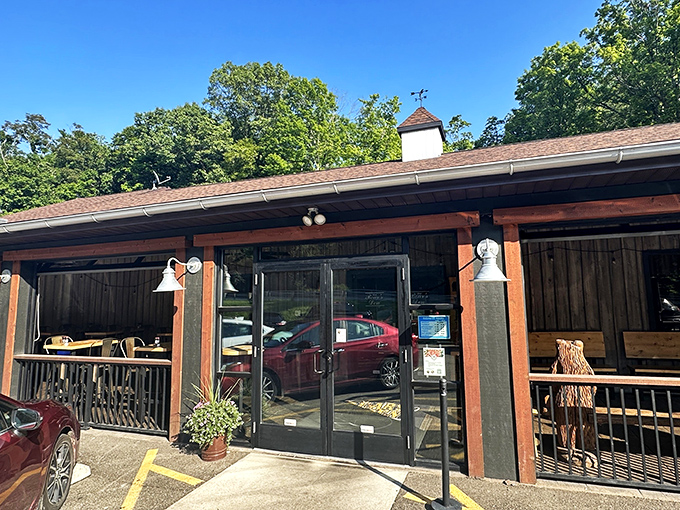 The rustic cabin exterior of Bear's Den Steakhouse promises a wilderness experience with gourmet credentials. That wooden bear statue isn't just decoration&mdash;it's a preview of coming attractions.
