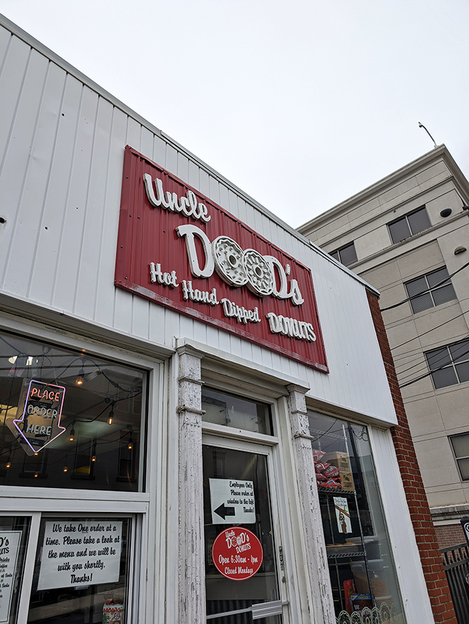 The iconic red and white sign promises "Hot. Hand. Dipped. Donuts." &mdash; four words that might be the sweetest poetry ever written on a storefront.