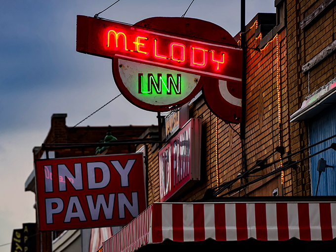 The neon glow of Melody Inn beckons like a lighthouse for music lovers, with its unassuming exterior hiding decades of Indianapolis rock history.