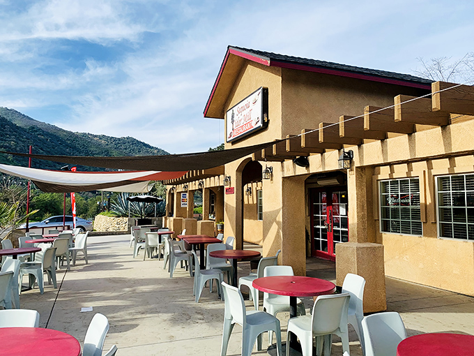 The stucco exterior with its distinctive red tables whispers "nothing fancy here" &ndash; but that's exactly what makes this Three Rivers gem so special.