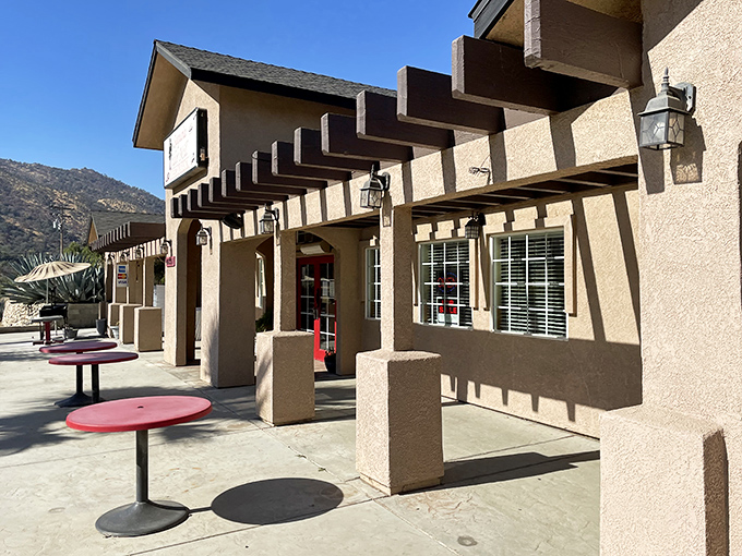 The stucco exterior with its distinctive red tables whispers "nothing fancy here" &ndash; but that's exactly what makes this Three Rivers gem so special.